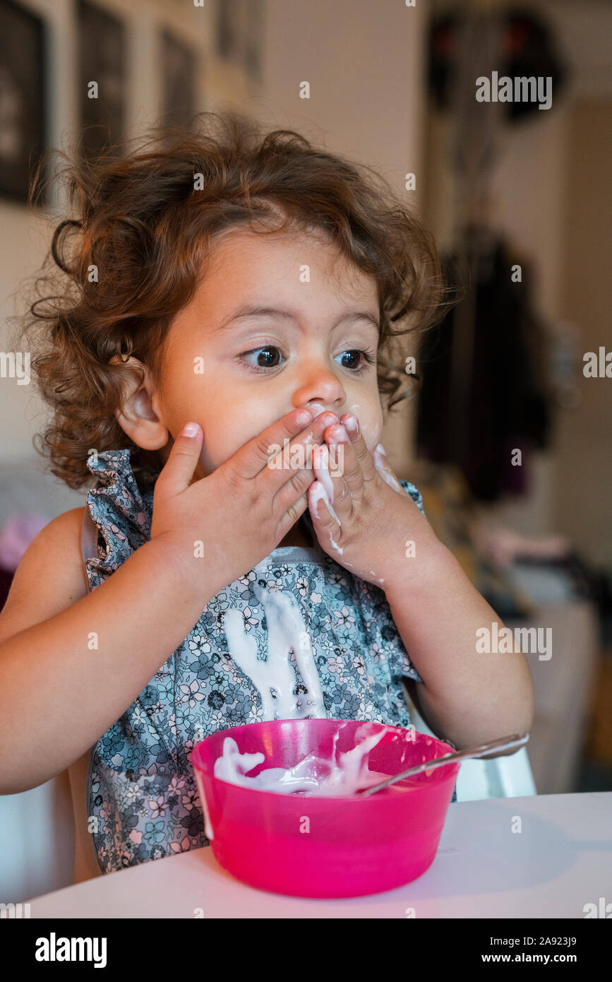 Toddler girl eating Stock Photo - Alamy