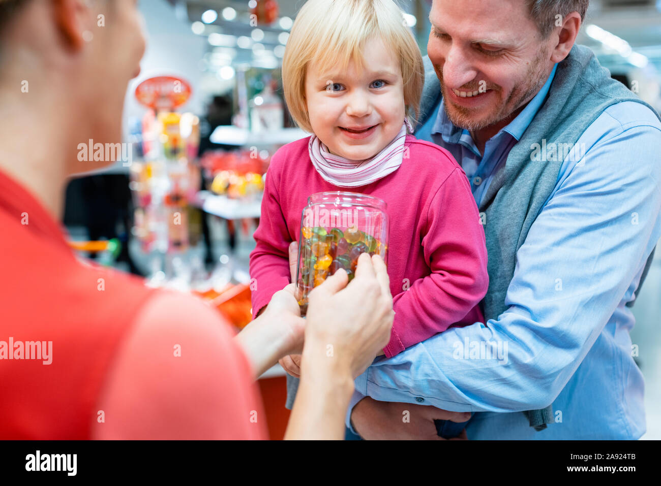 Child grabbing some sweets out of a jar in the candy store Stock Photo ...