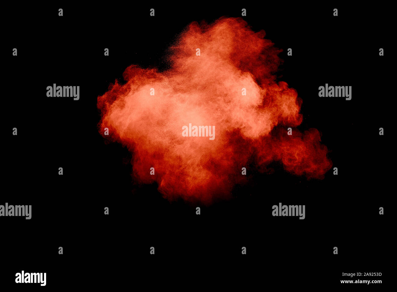 Orange powder dust particles explosion on black background.Orange dust ...