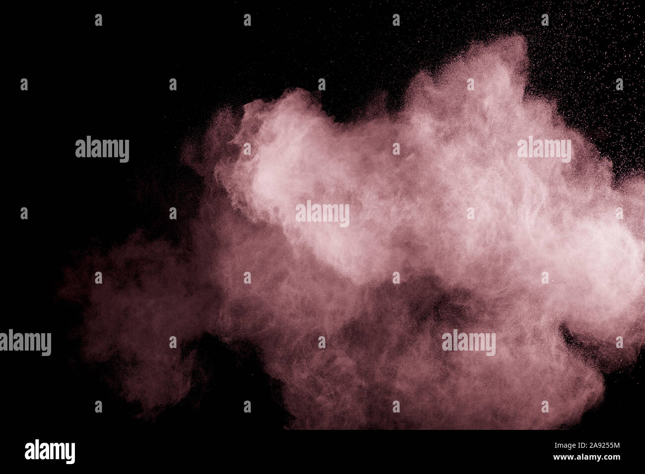 Abstract pink dust explosion on black background. Freeze motion of pink ...