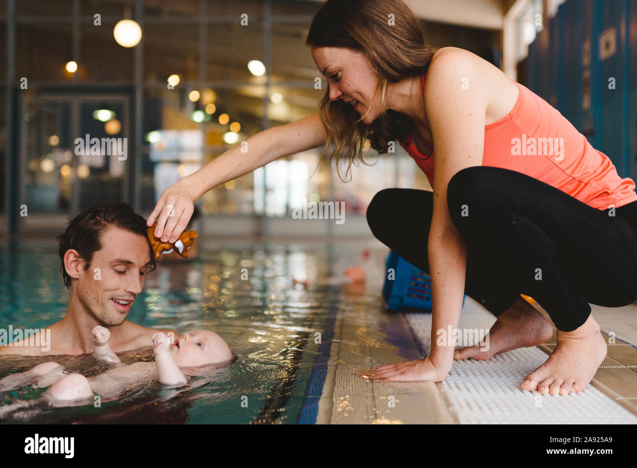 Parents with baby in swimming-pool Stock Photo - Alamy