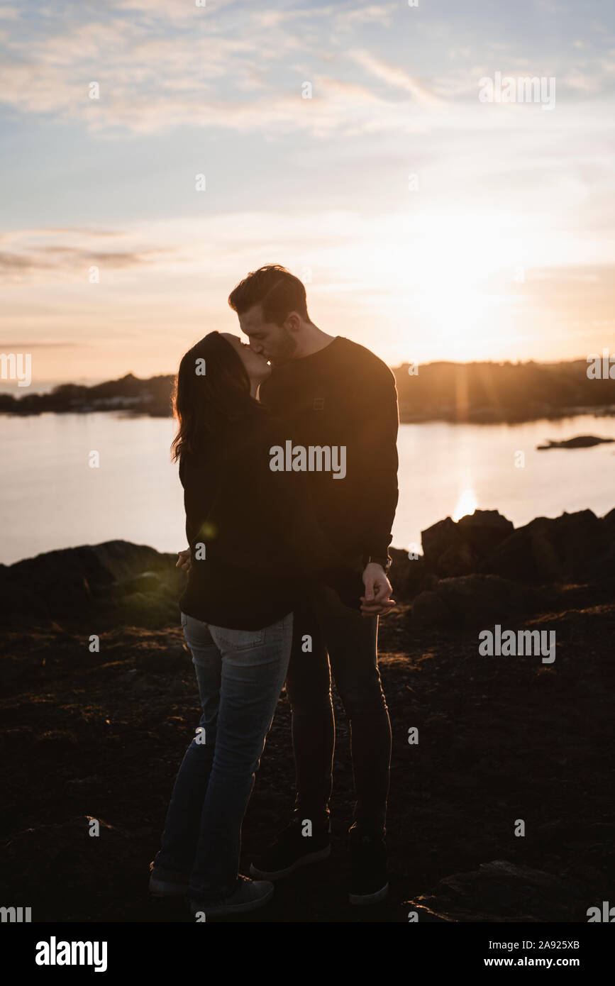 Couple kissing at sunset Stock Photo - Alamy