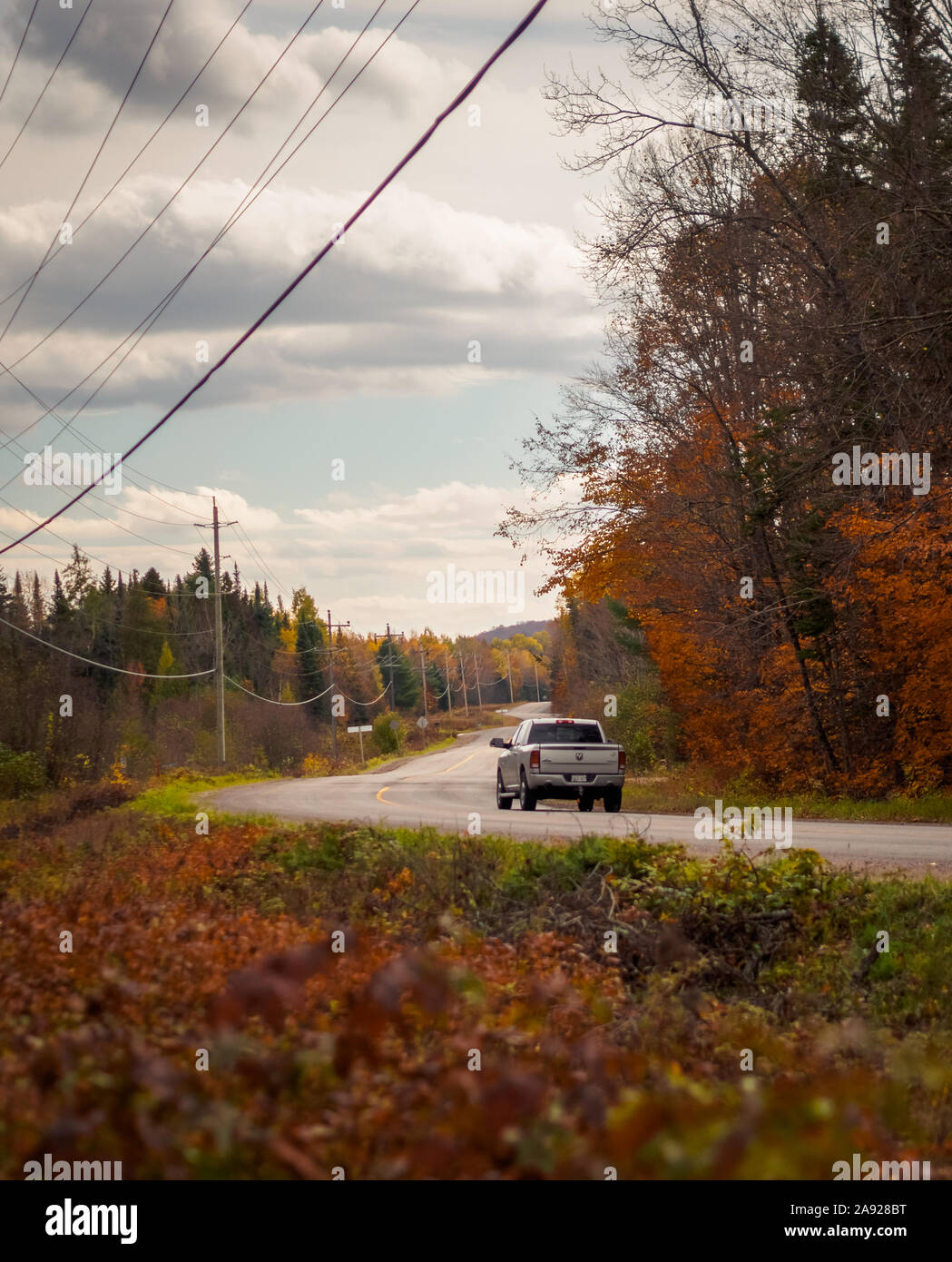 A car driving down on a road in Dysart et al with colorful trees in the ...