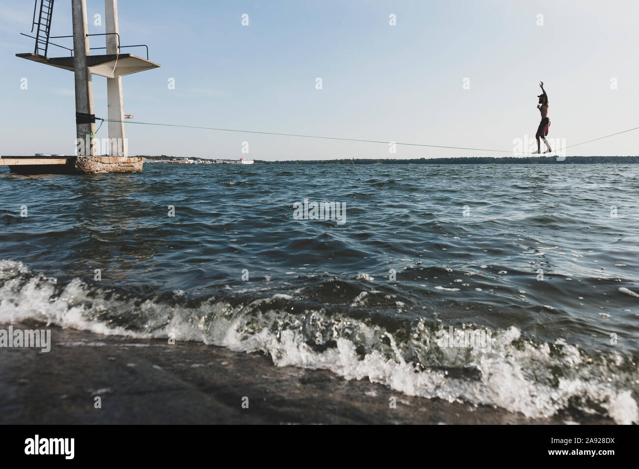 Person on slickline above sea Stock Photo - Alamy