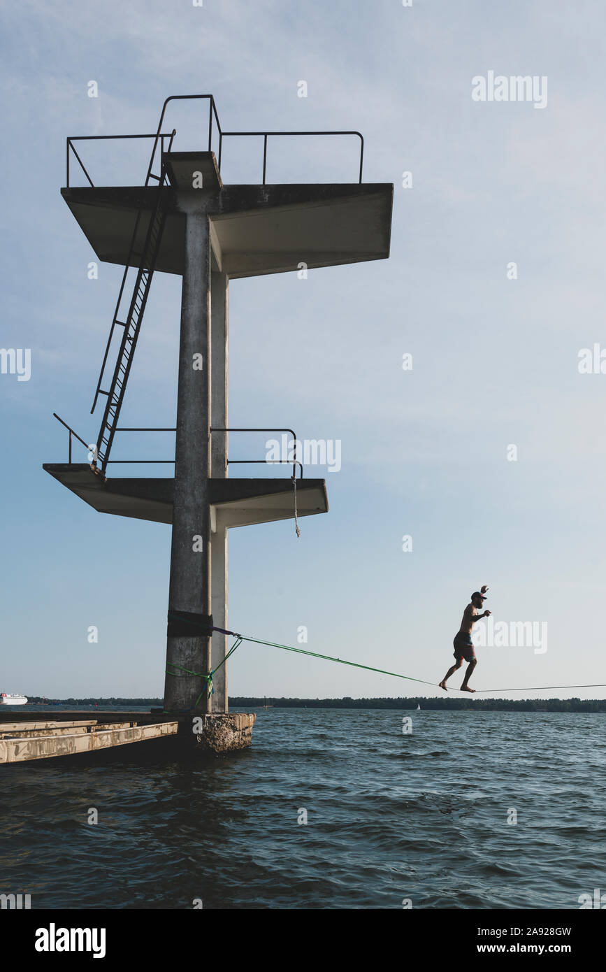 Person on slickline above sea Stock Photo - Alamy