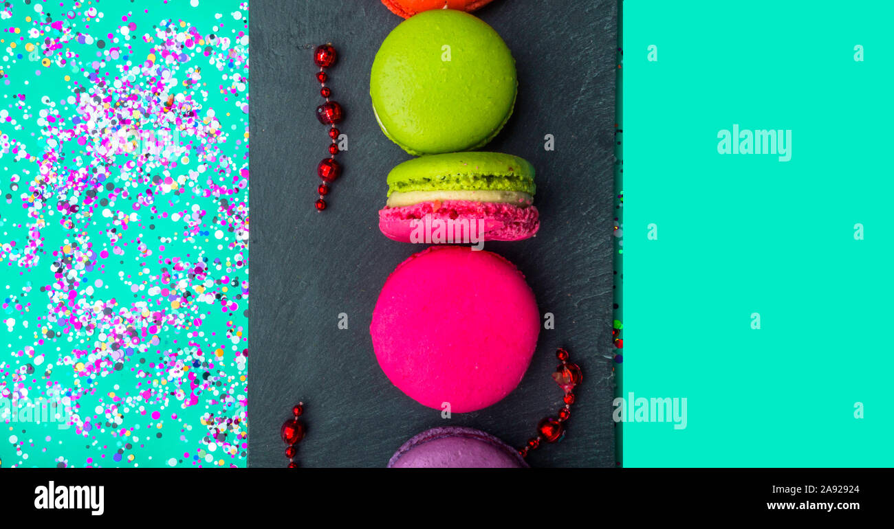 Colorful macaroons at stone slate on trendy mint green color background ...