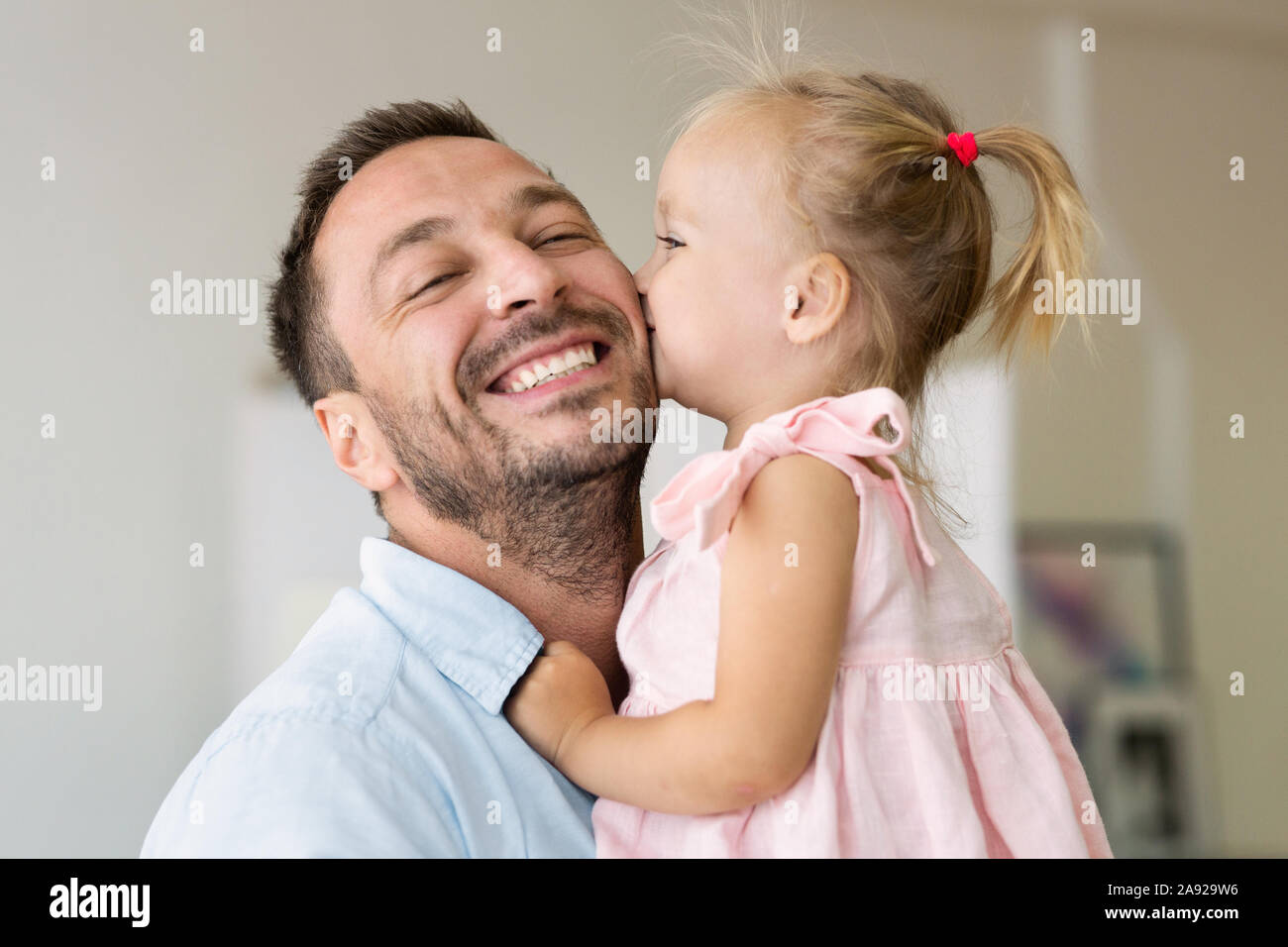 Portrait of adorable daughter kissing her father Stock Photo - Alamy