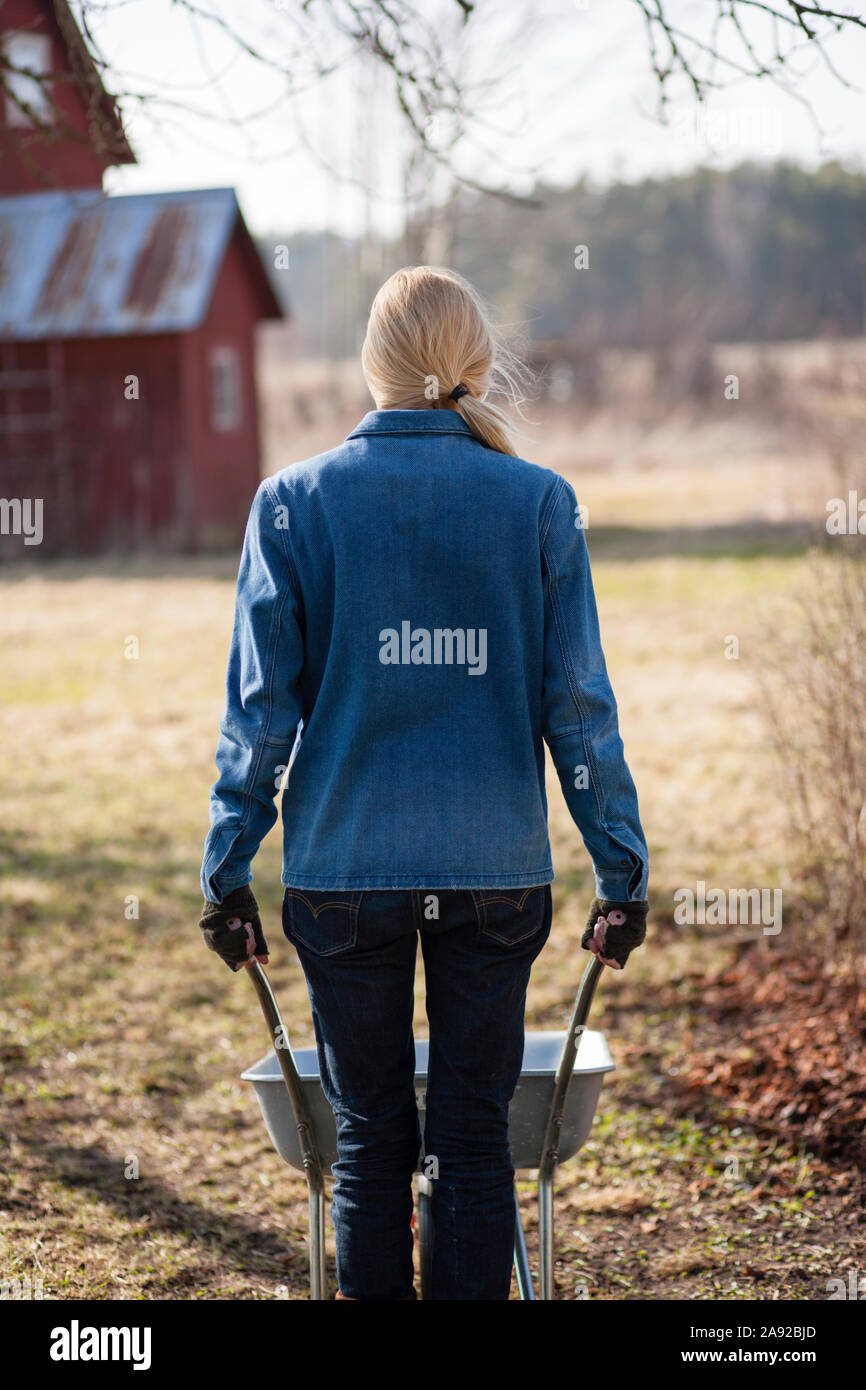 Woman pushing wheelbarrow hi-res stock photography and images - Alamy