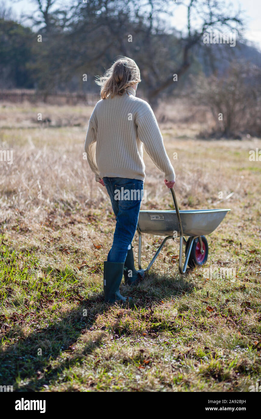 Woman pushing wheelbarrow hi-res stock photography and images - Alamy