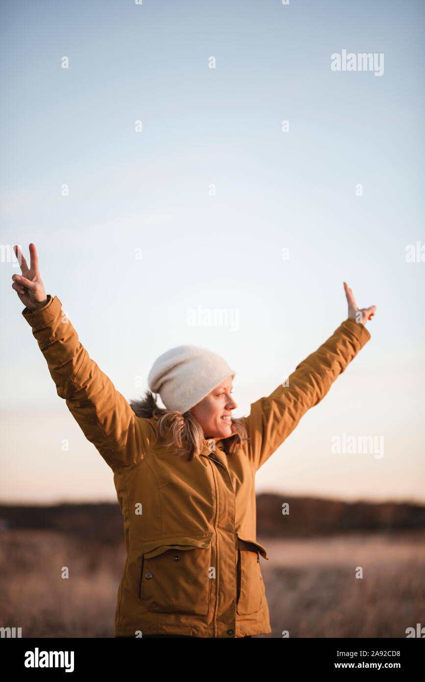 Woman doing peace sign Stock Photo - Alamy
