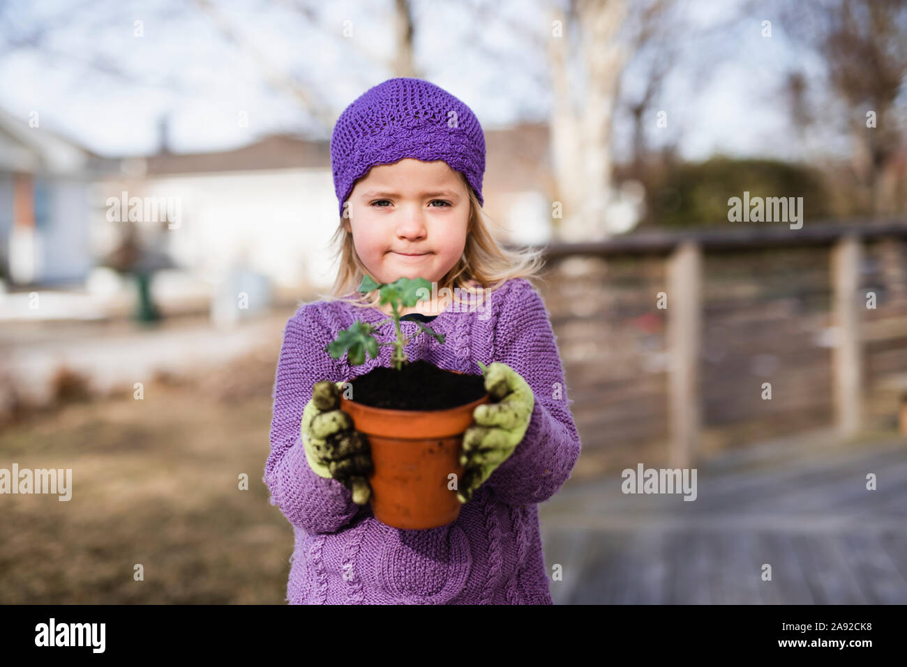 Girl holding pot with plant Stock Photo - Alamy