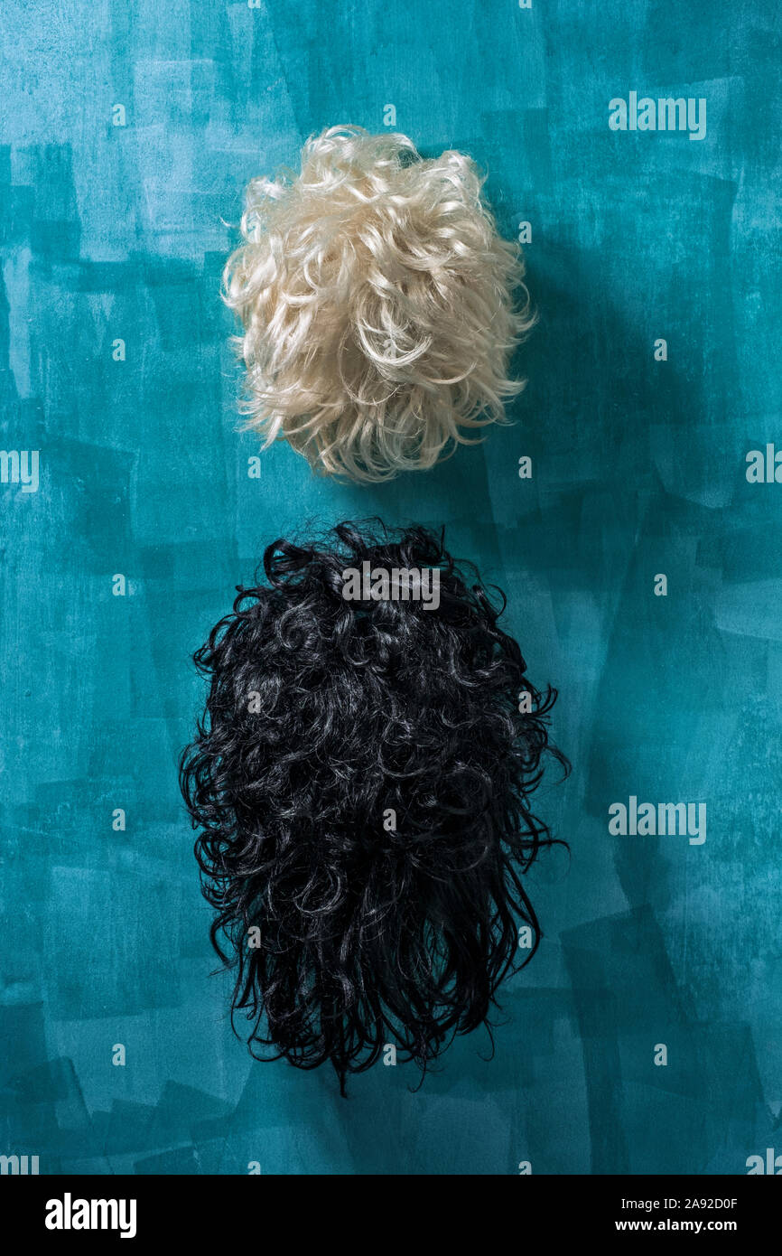 Two wigs hanging on a wall Stock Photo - Alamy