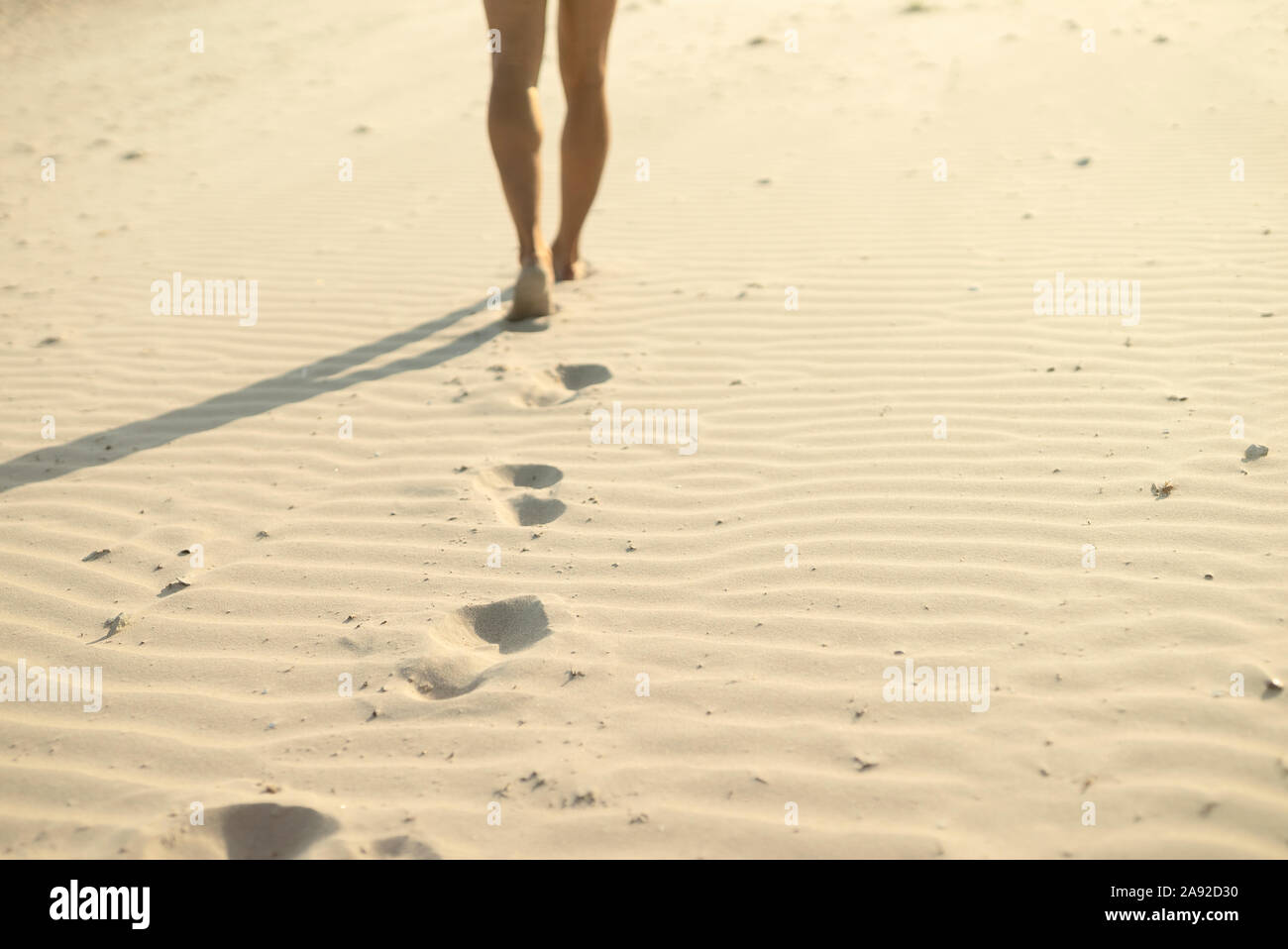 Woman walking on sand Stock Photo - Alamy