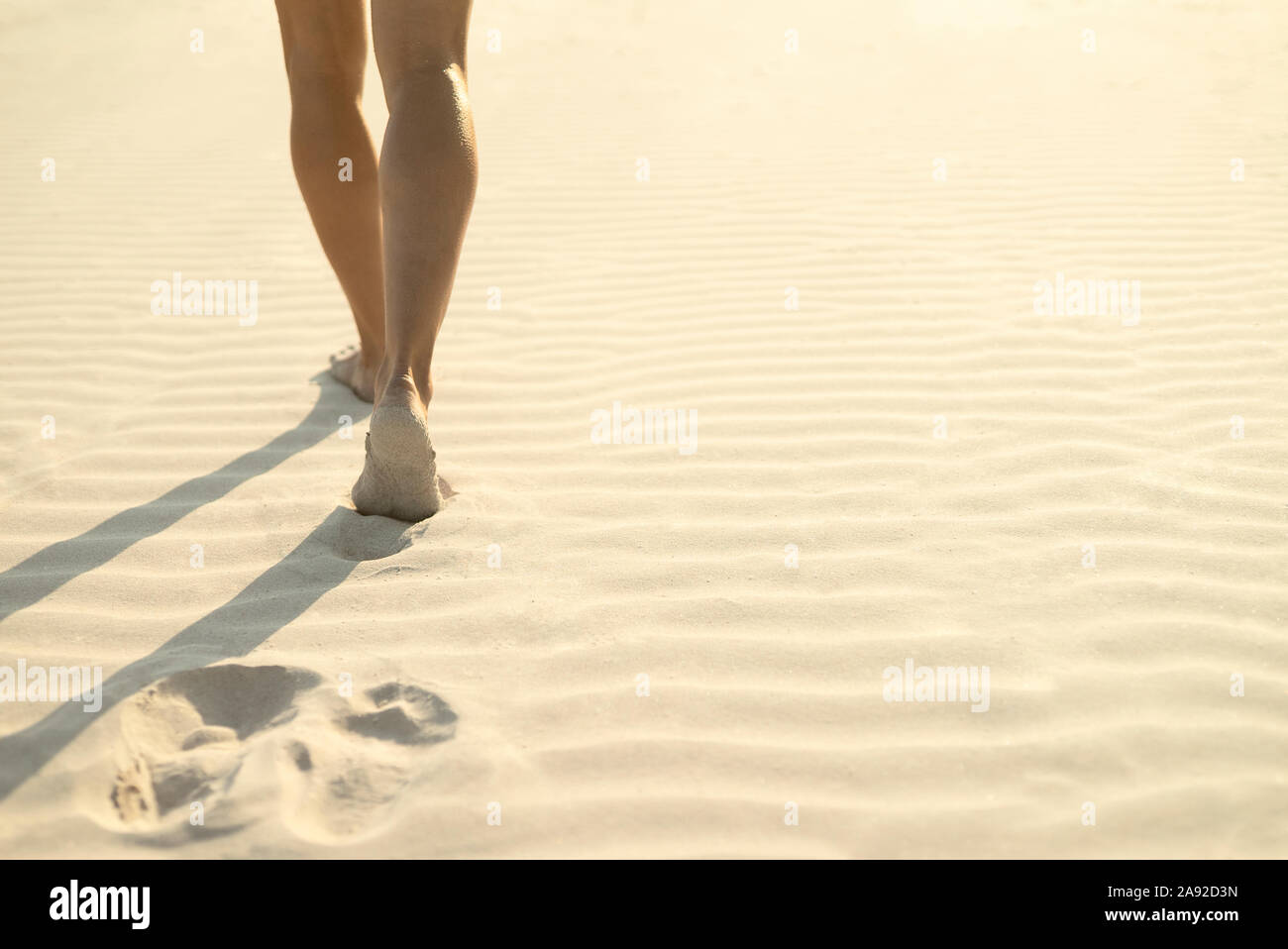 Woman walking on sand Stock Photo - Alamy