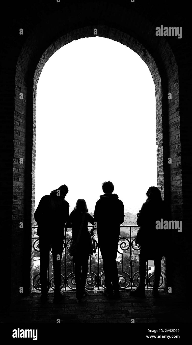 family with four people without father under the arcade with black and ...