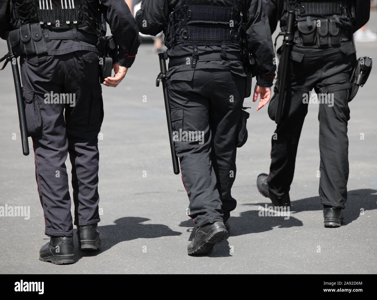 three cops patroling the road with guns and black uniform Stock Photo ...
