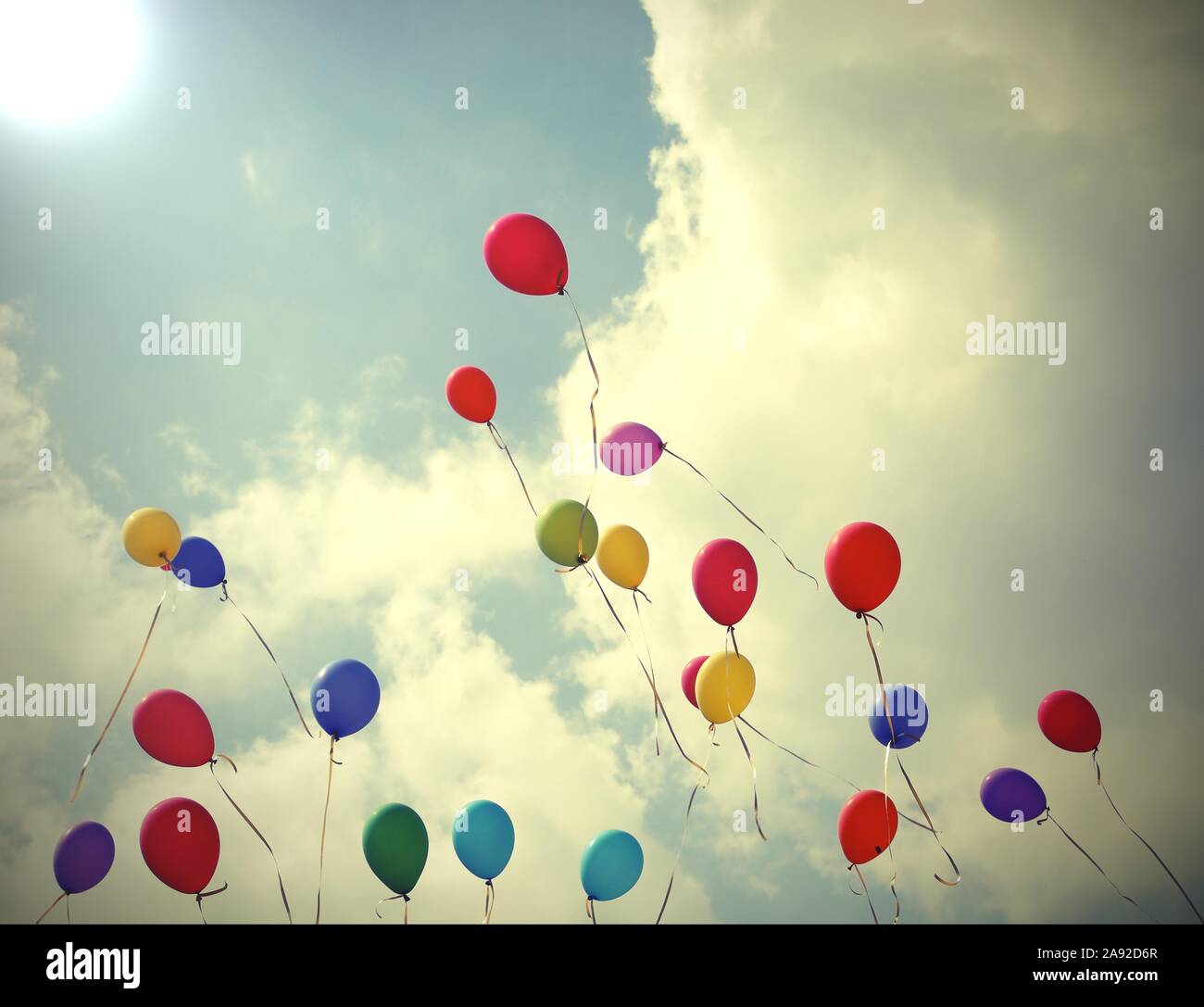 many colred balloons flying on the blue sky with clouds during a party ...