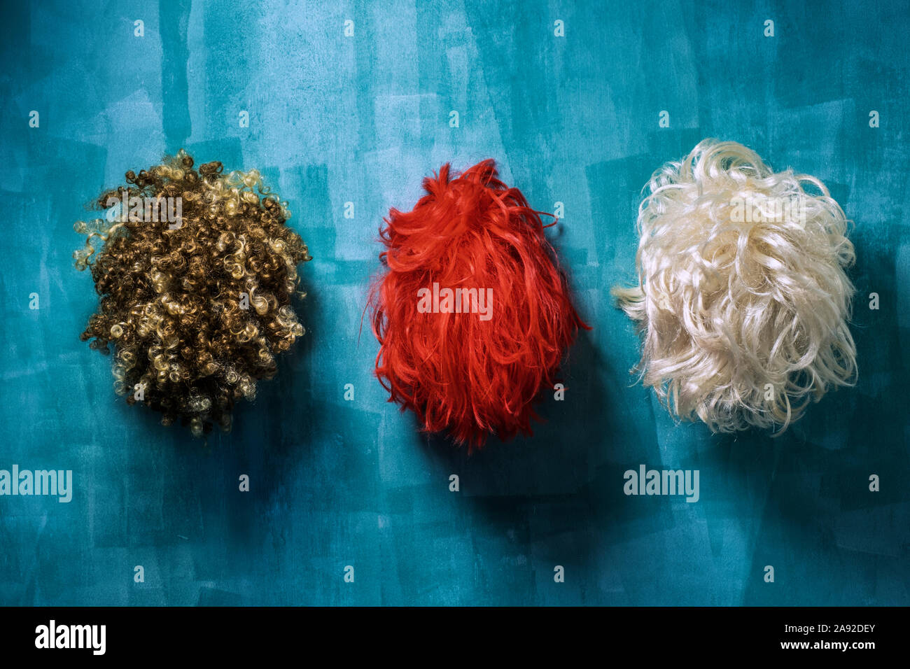 Three wigs hanging on a wall Stock Photo - Alamy