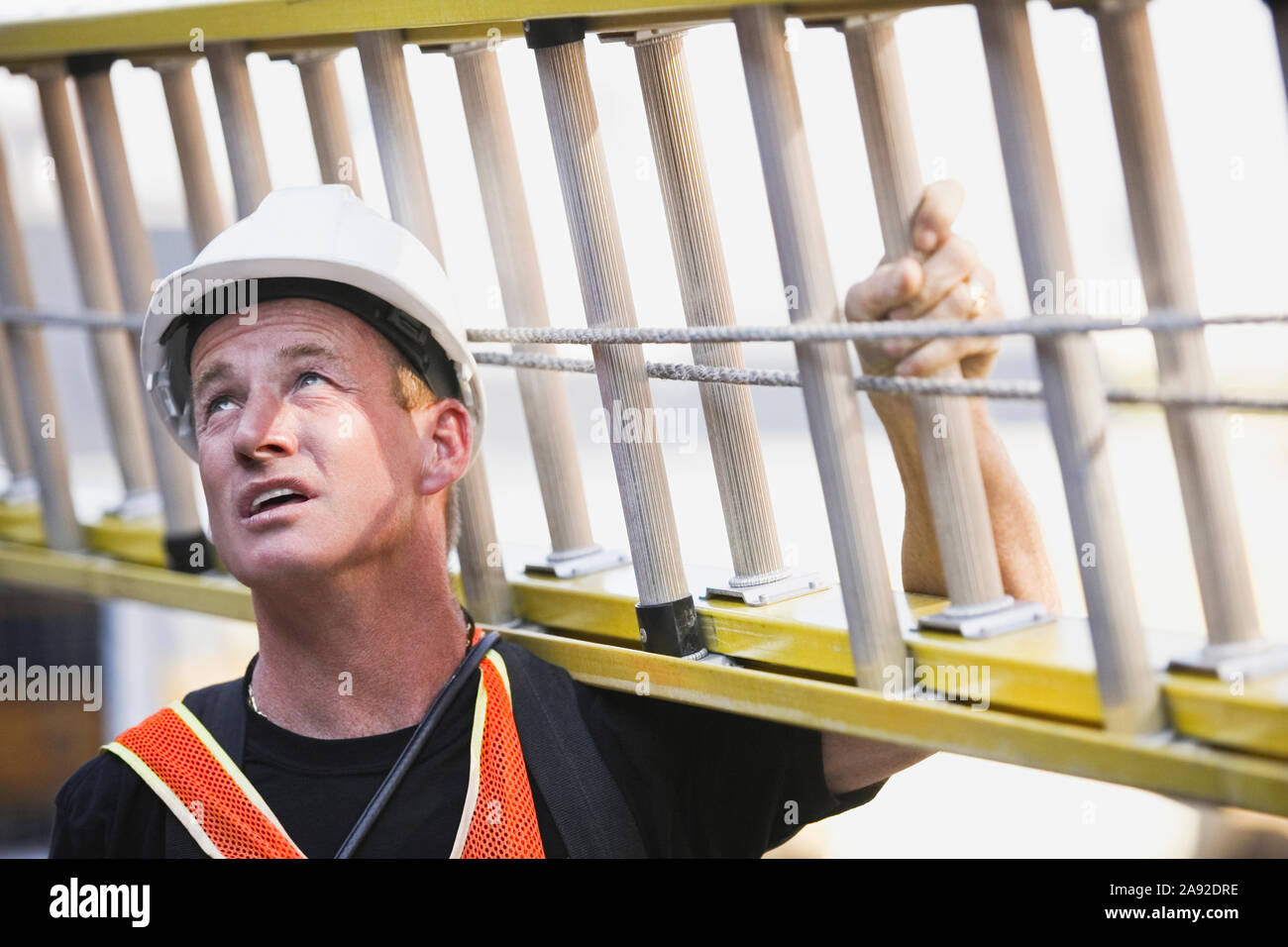 Lineman carrying a ladder Stock Photo - Alamy