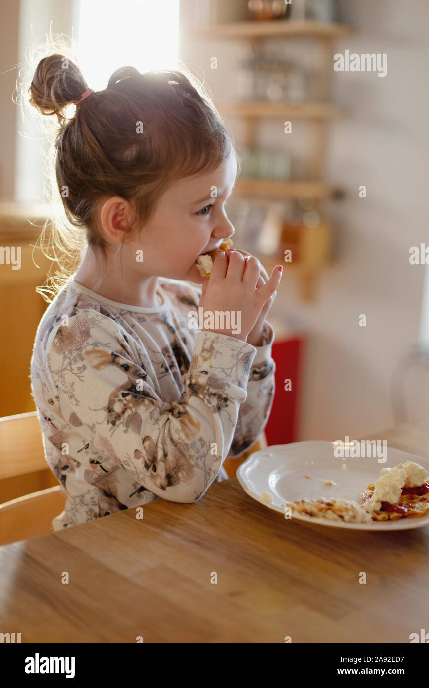 Girl eating at table Stock Photo - Alamy