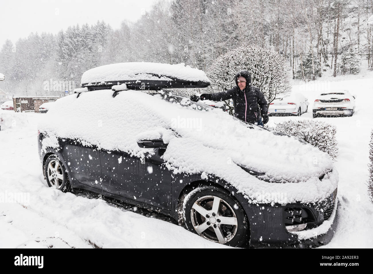 Woman clearing snow from car Stock Photo - Alamy