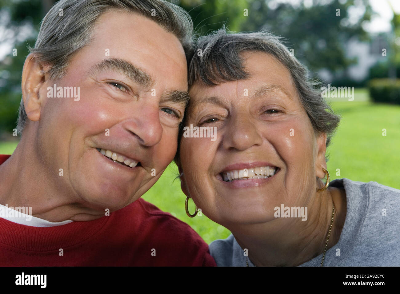Portrait of a senior couple smiling in a park Stock Photo - Alamy