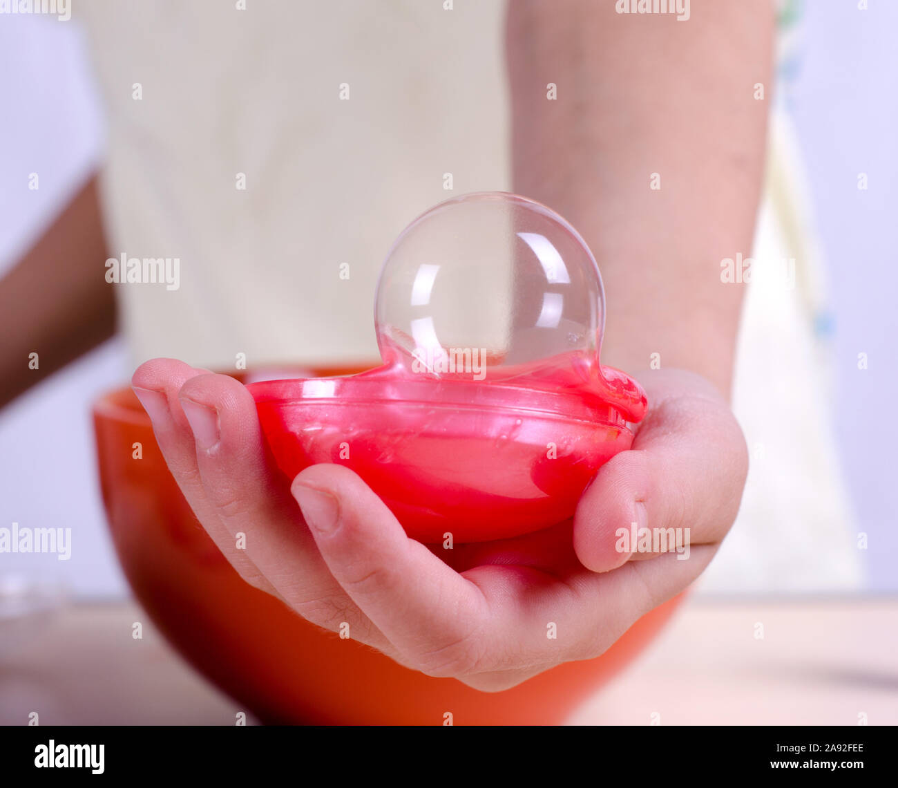 Adorable caucasian little girl holding slime toy, worldwide popular ...