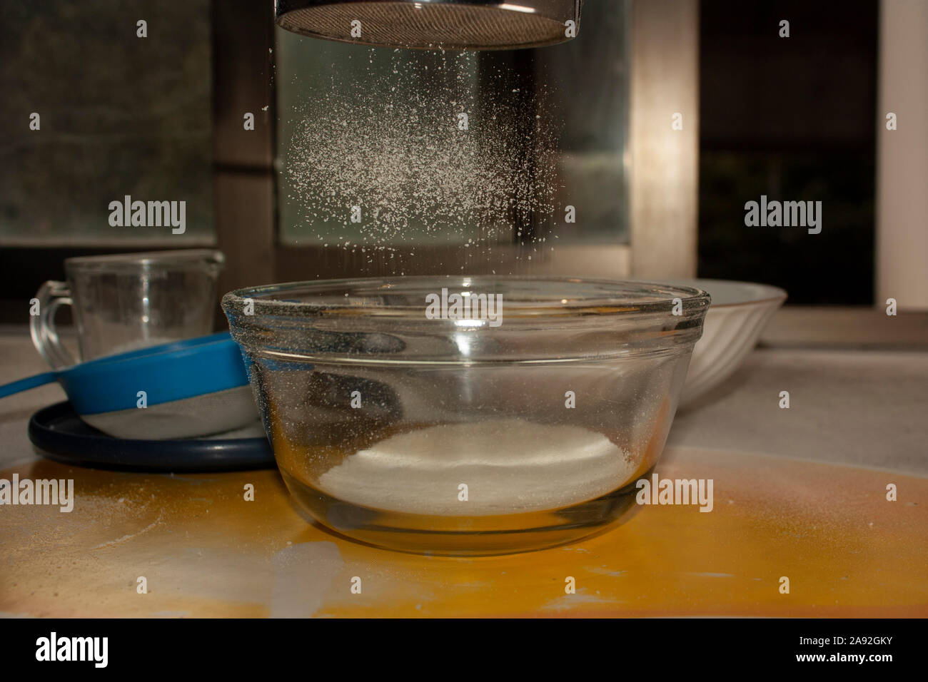 Rain of glass sugar falling in the form of rain from the sifter to the ...