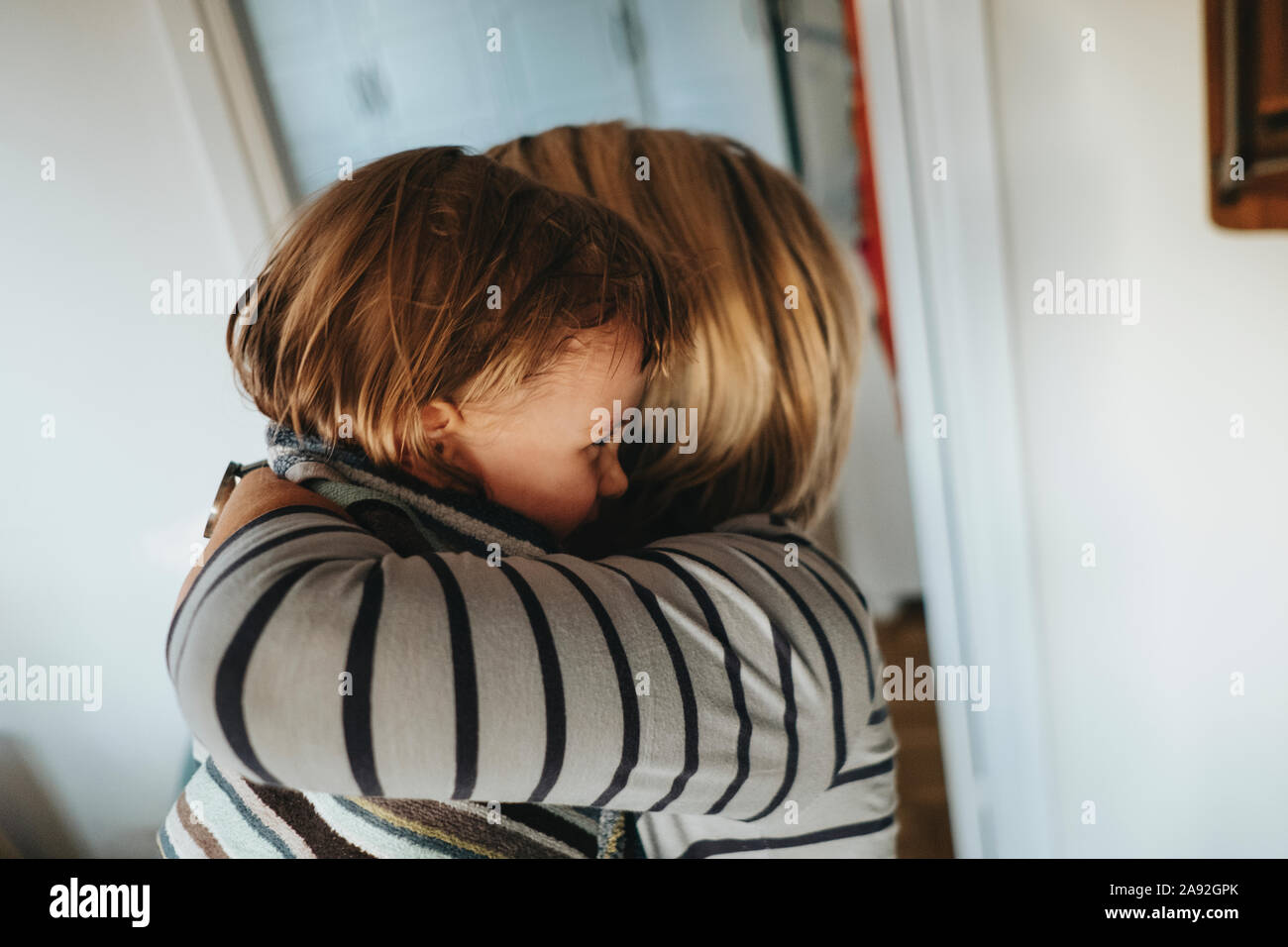 Toddler girl having hug from mum Stock Photo - Alamy
