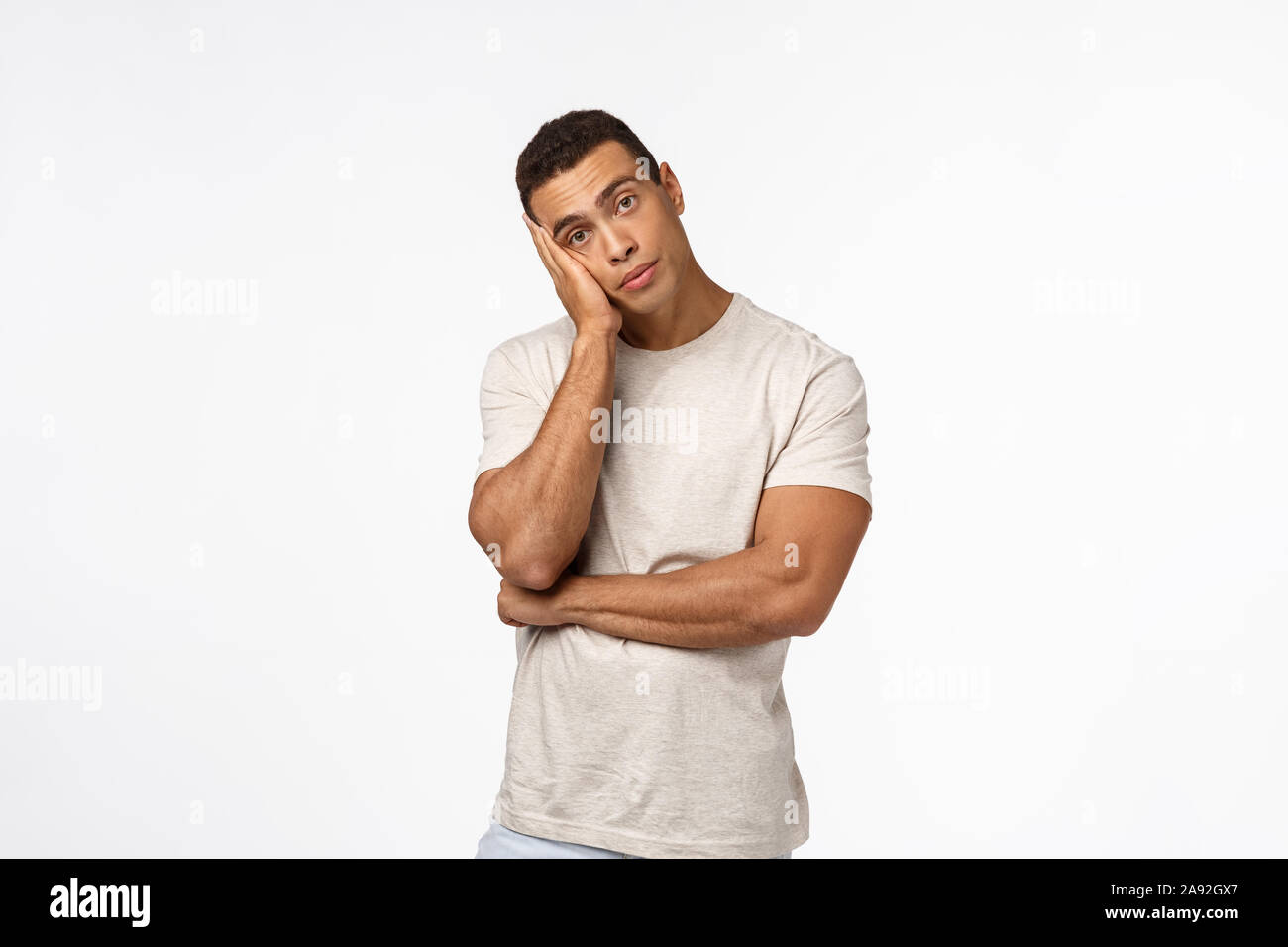 Annoyed and fed up handsome bored man, leaning on palm, stare blank and ...