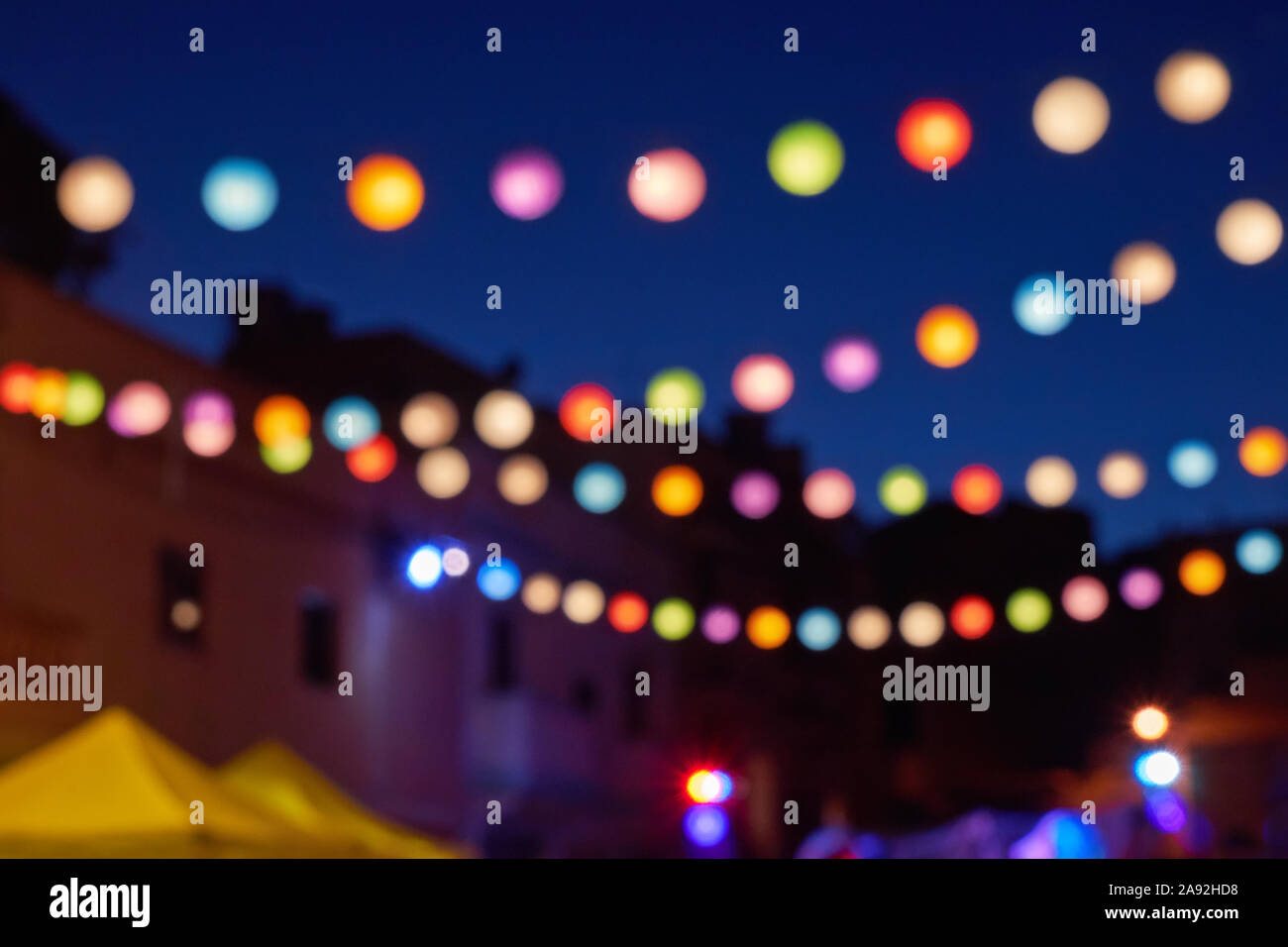 Blurred defocused background with street decorated with burning colored ...