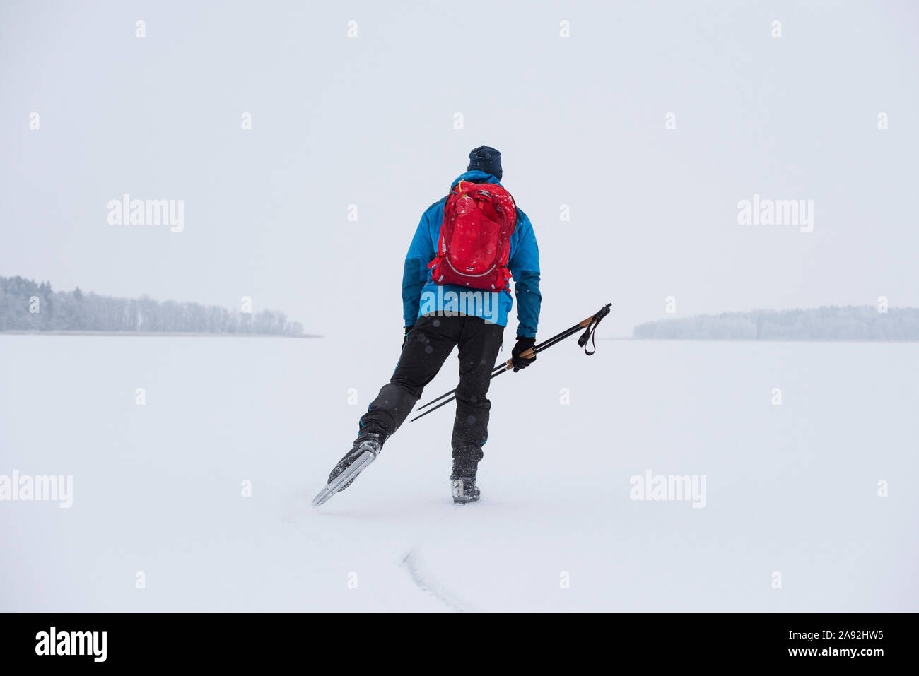 Man ice-skating on frozen lake Stock Photo - Alamy