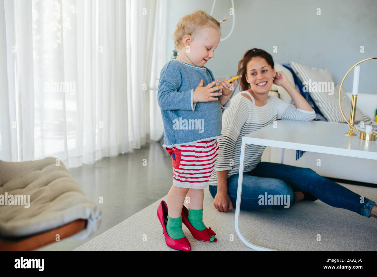 Mother with daughter using cell phone Stock Photo - Alamy