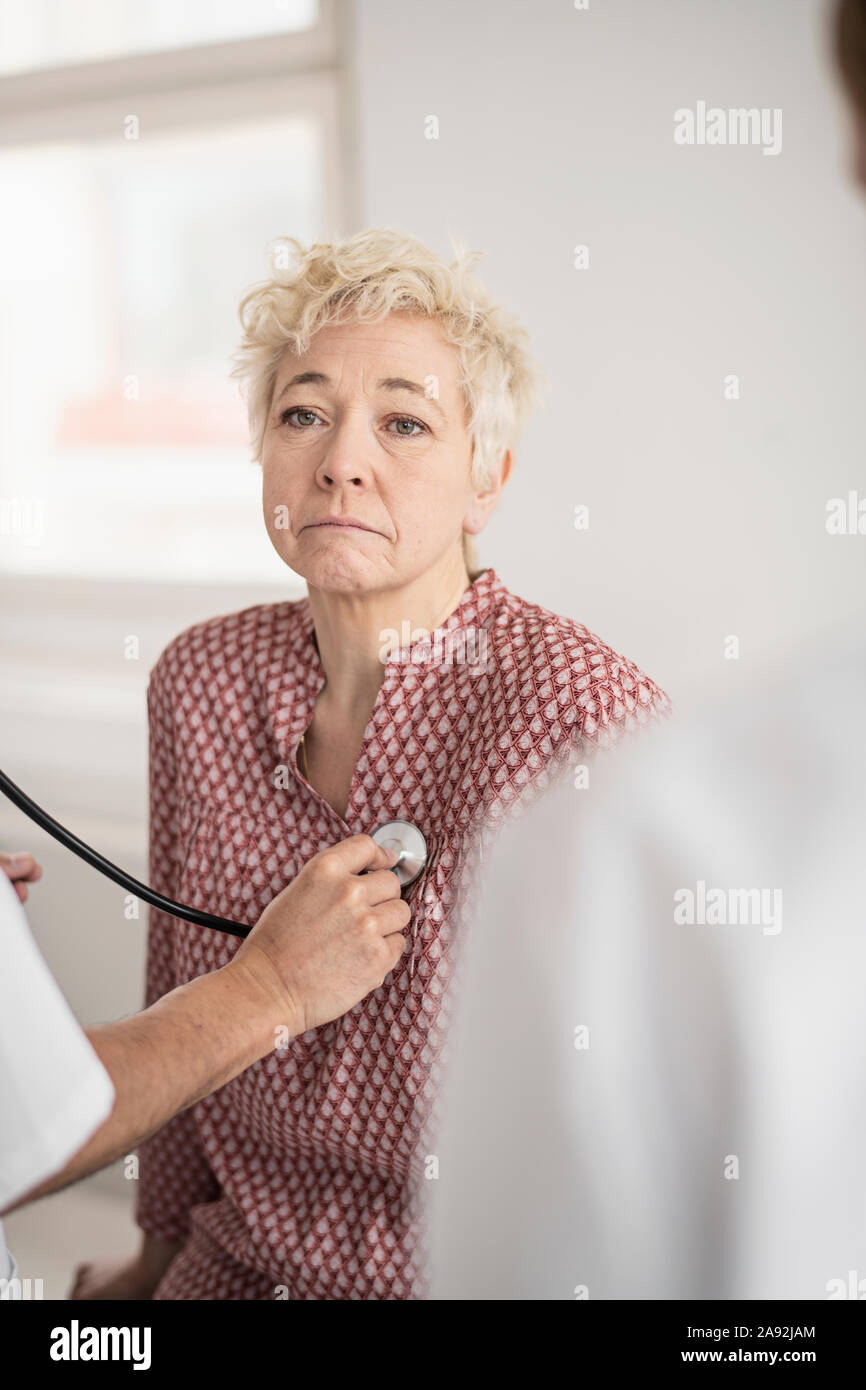 Doctor with stethoscope examining patient Stock Photo - Alamy
