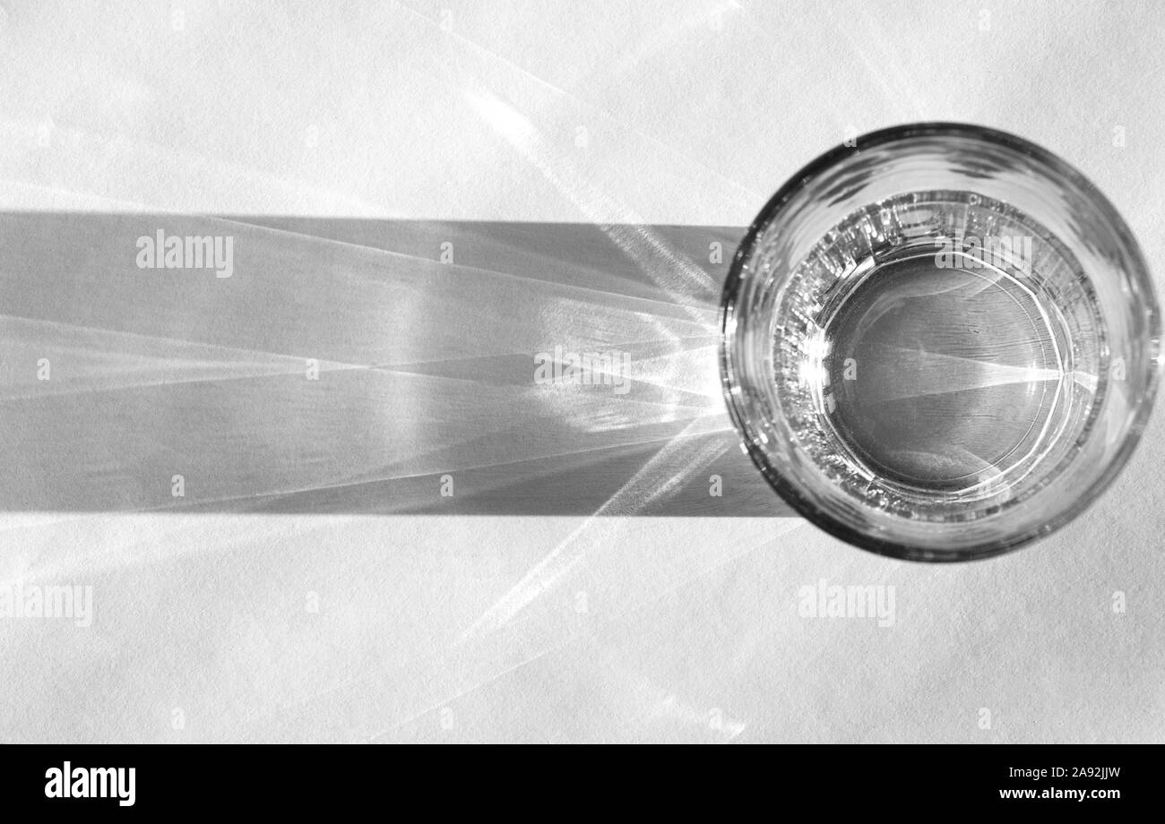 Water glass with strong shadows on white background Stock Photo - Alamy