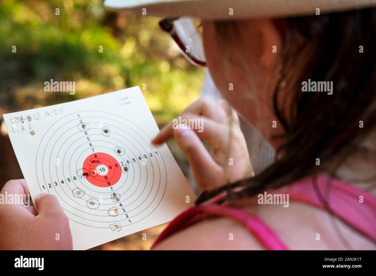 Girl checking shooting target Stock Photo - Alamy