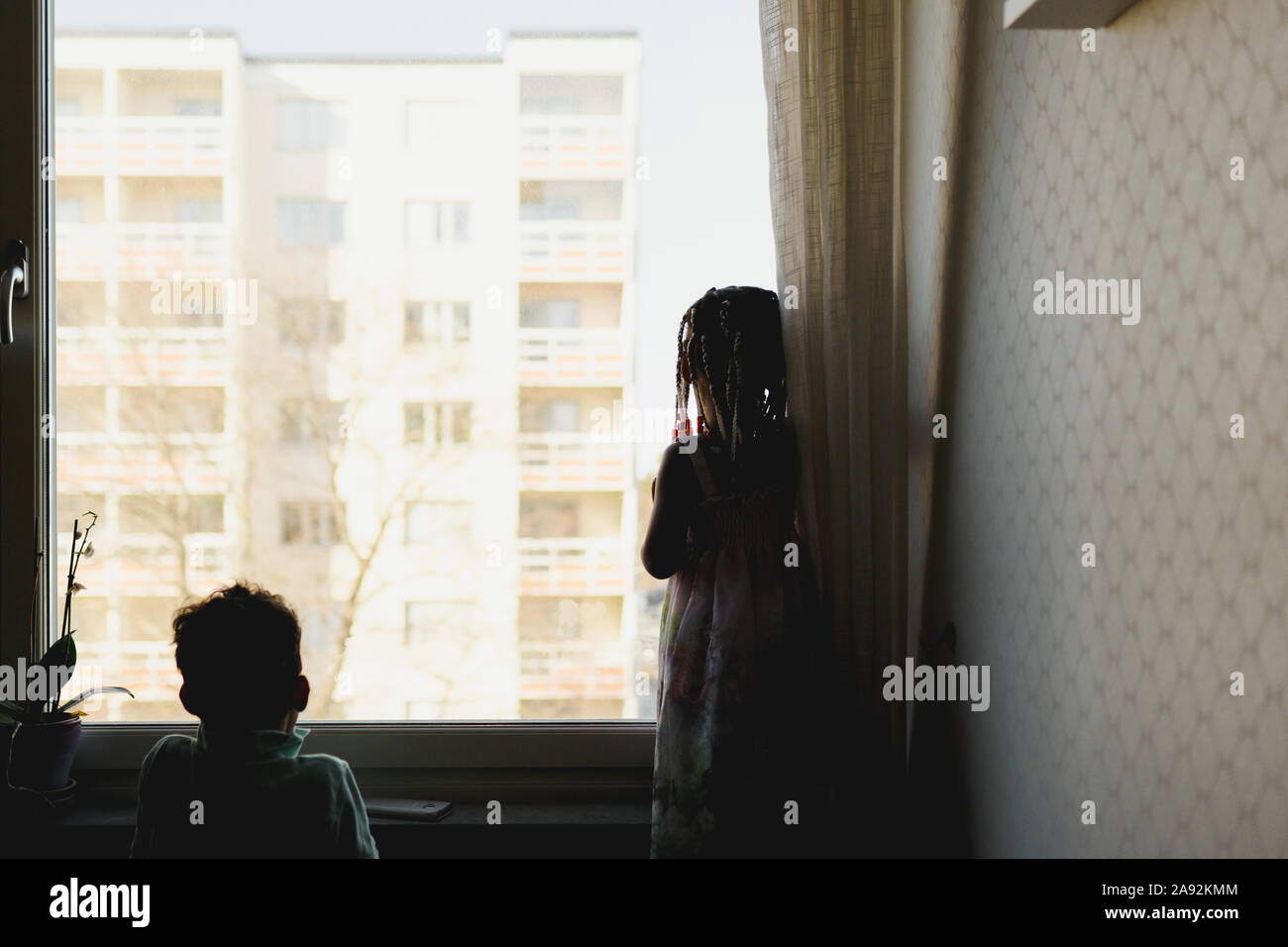Girl looking through window Stock Photo - Alamy