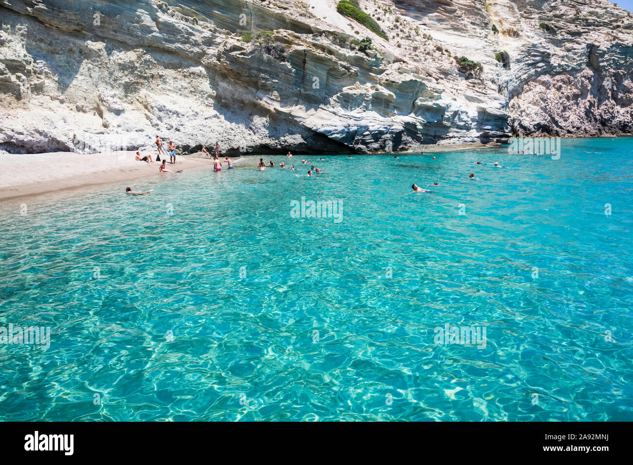 Tourists swimming in the clear, turquoise water of Galazia Nera Bay ...