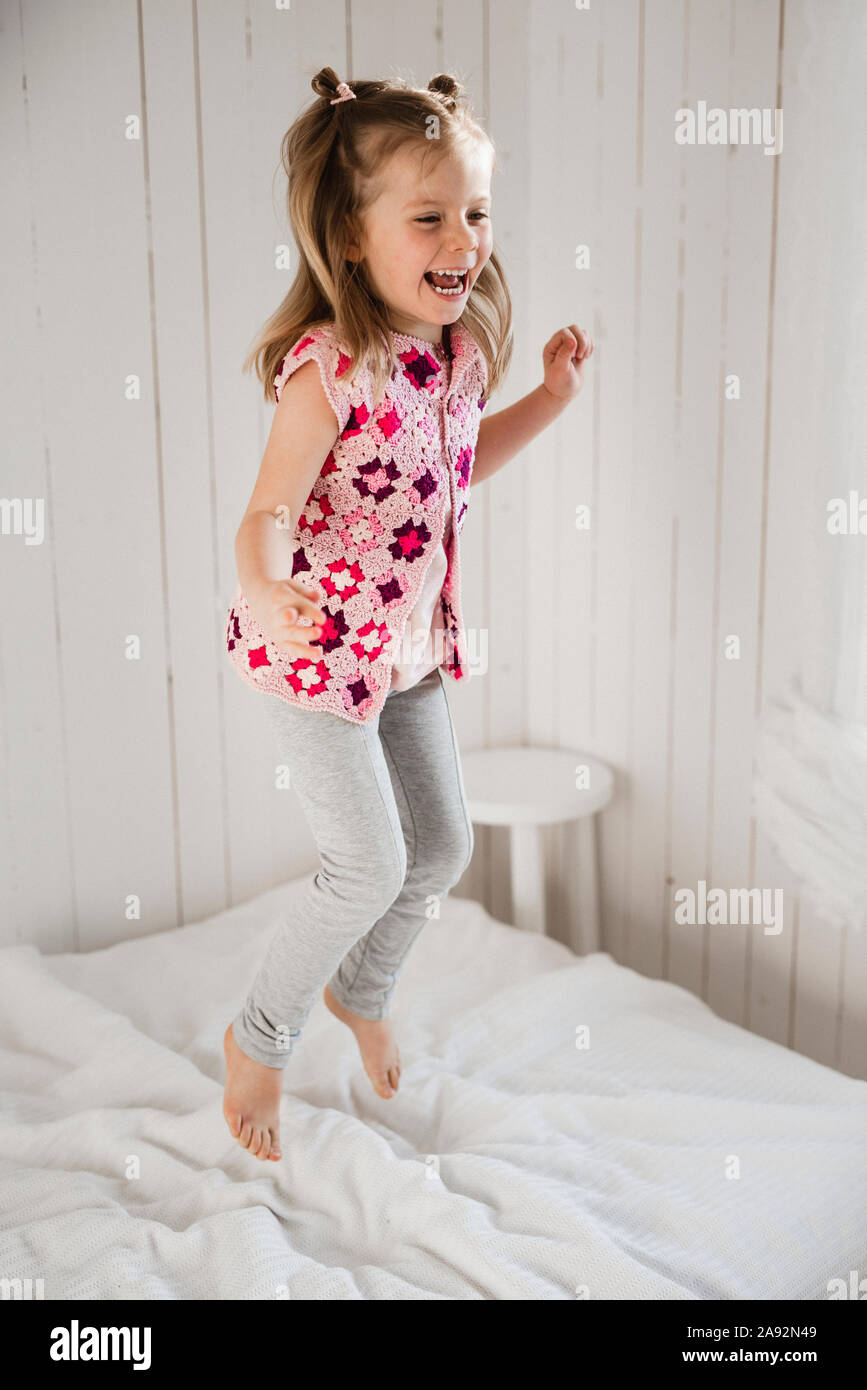 Girl jumping on bed Stock Photo - Alamy