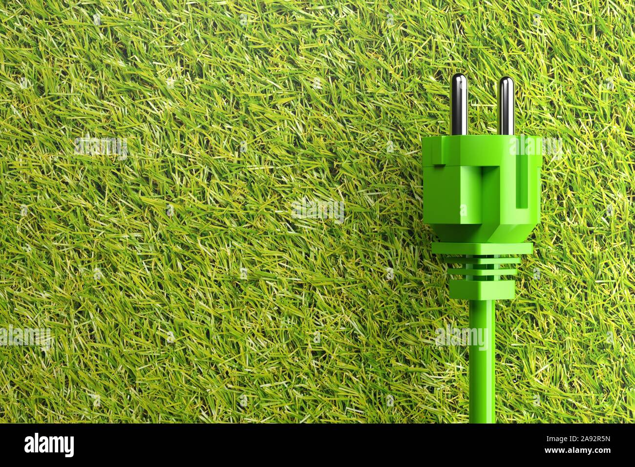 Green power cord with plug on grass background with copy space - eco or ...