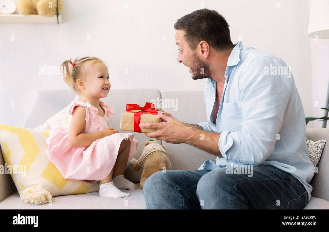 Father giving birthday present for happy daughter Stock Photo - Alamy