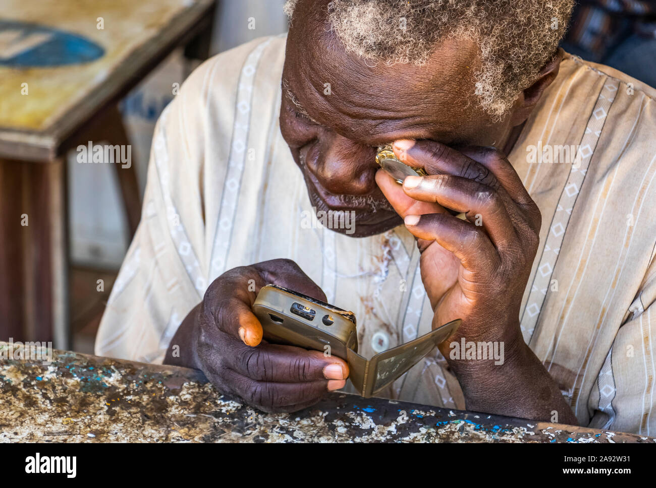 Sudanese man repairing a mobile phone; Kerma, Northern State, Sudan ...