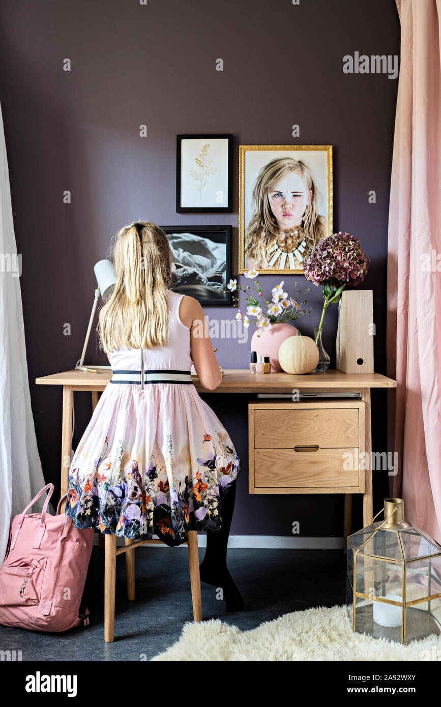Girl sitting at desk Stock Photo - Alamy