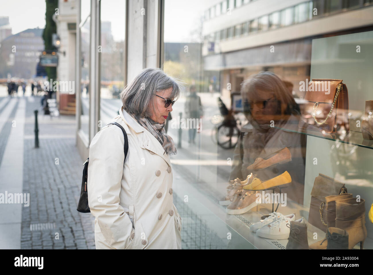 Woman looking in shop window Stock Photo - Alamy