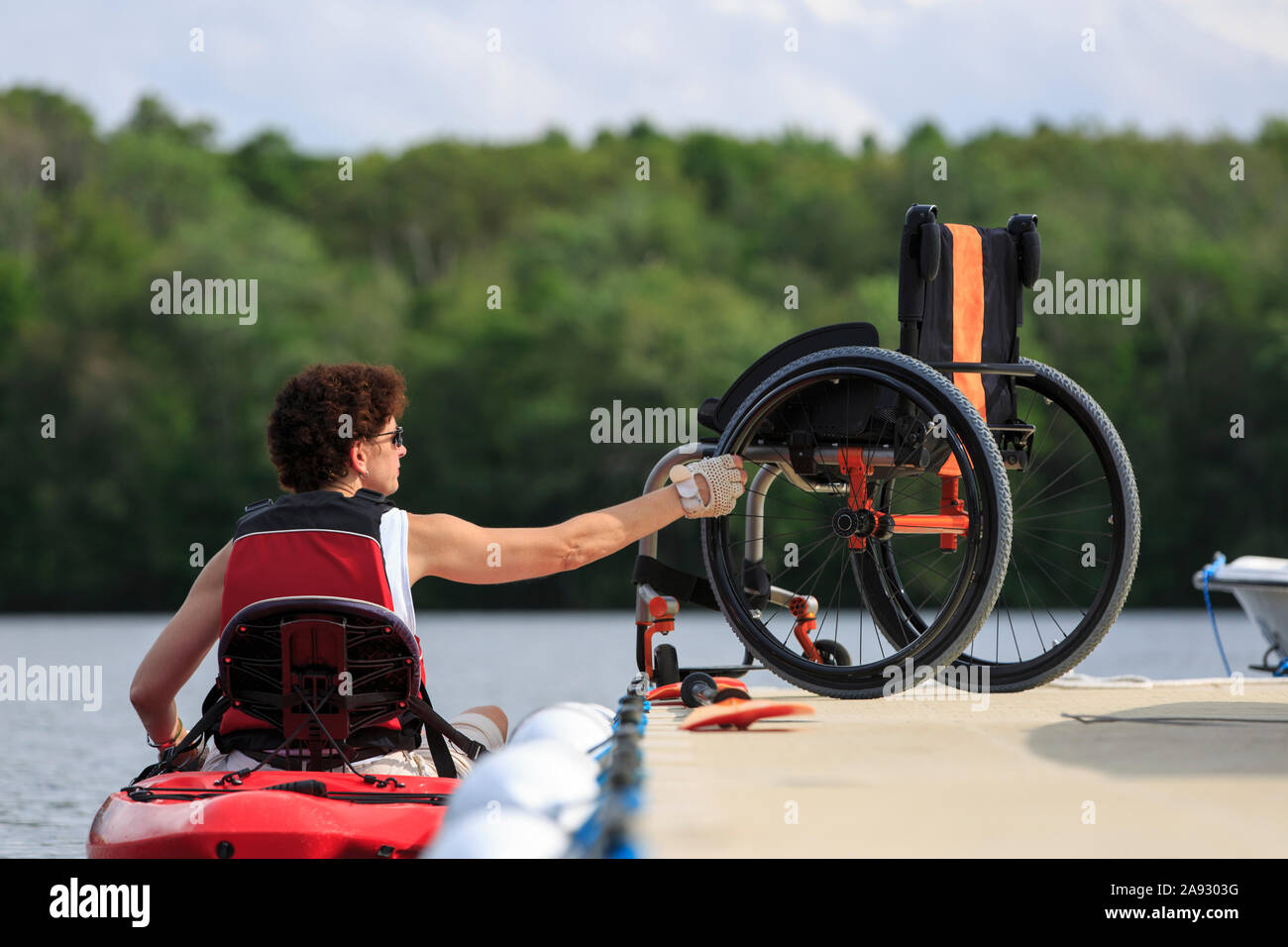 Woman with a Spinal Cord Injury learning how to use a kayak Stock Photo ...