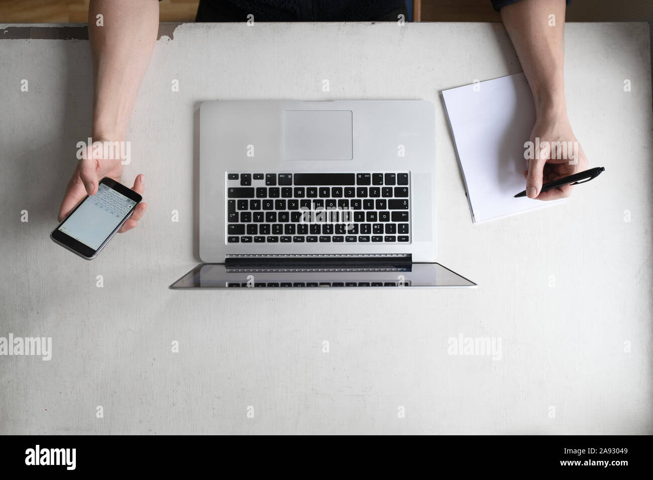 Hands with cell phone and laptop Stock Photo - Alamy