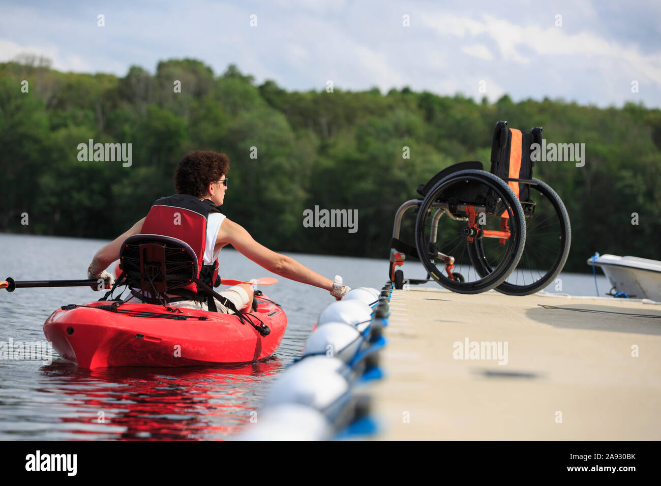 Woman with a Spinal Cord Injury learning how to use a kayak Stock Photo ...