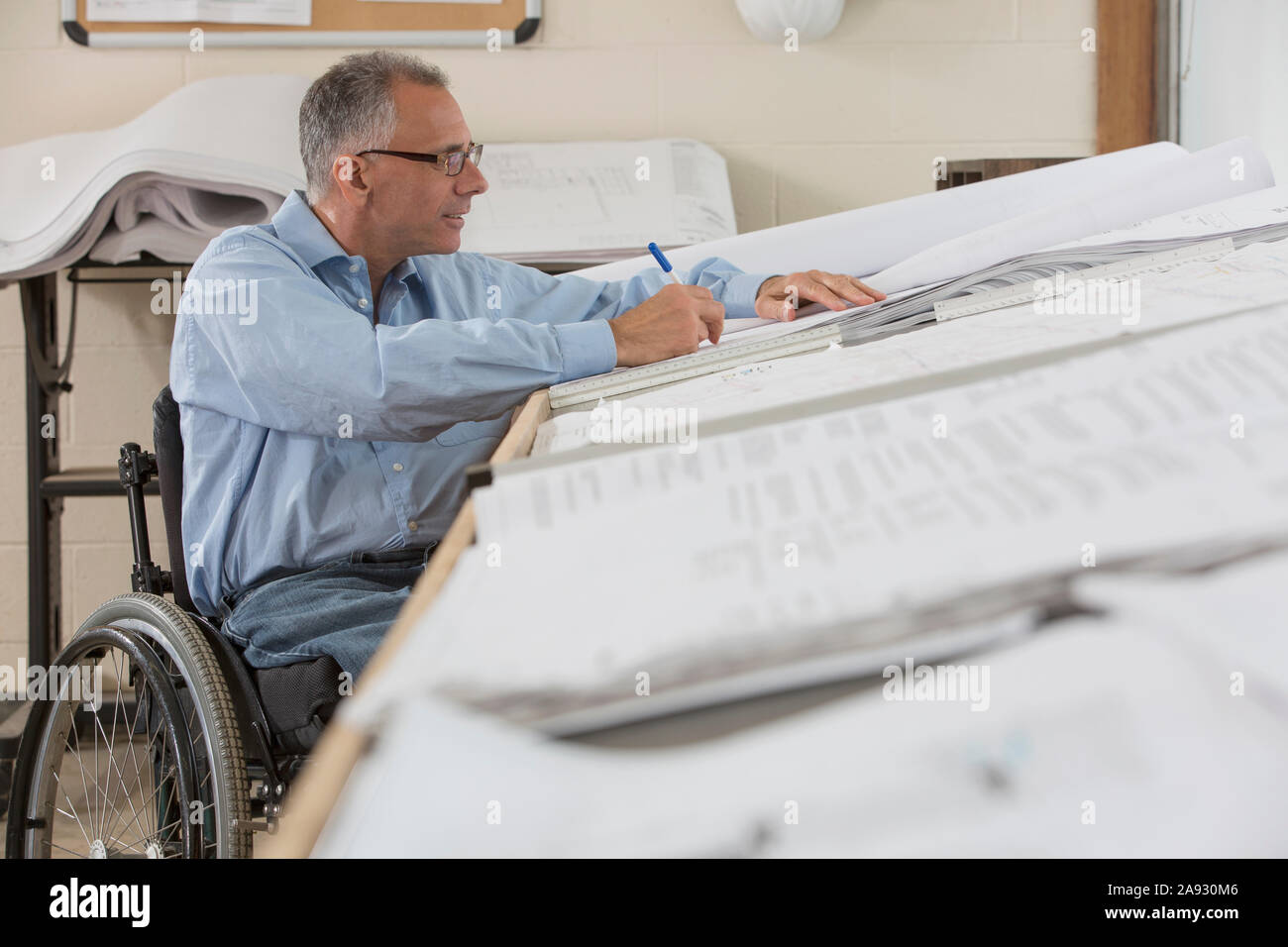 Project engineer with a Spinal Cord Injury in a wheelchair working on ...