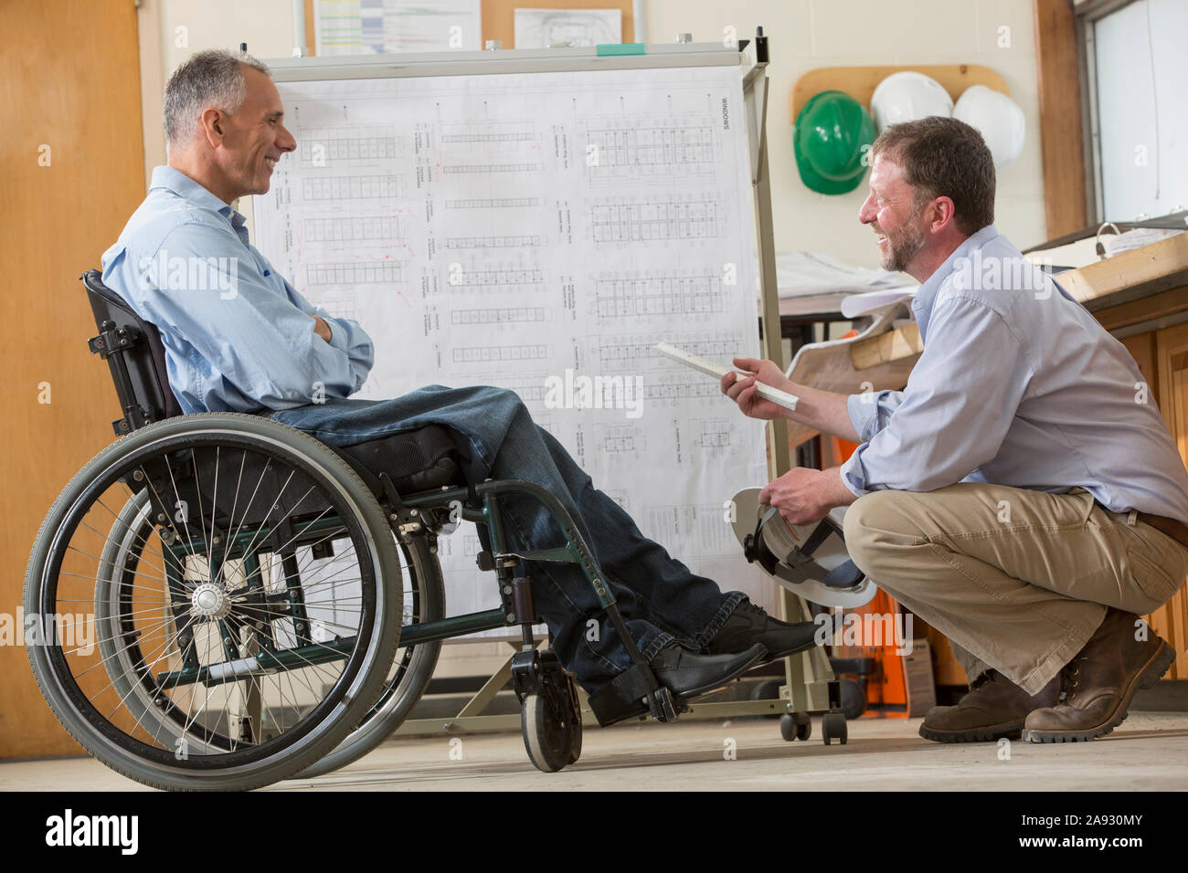 Two project engineers using a hanging rack for job site plans, one in a ...
