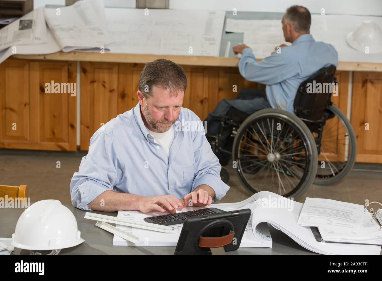 Two project engineers doing paperwork about the job, one in a ...